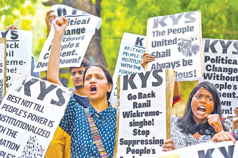 Demonstrators hold placards as they shout slogans during a protest