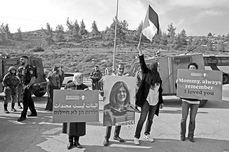 Activists of Combatants for Peace hold placards during a demonstration